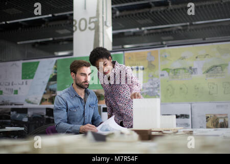 Colleagues discussing architectural plans together Stock Photo - Alamy