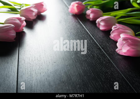 Border from bright pink tulips flowers on black wooden background Stock ...