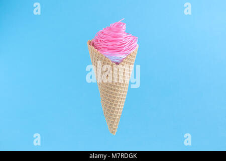Ice cream made of colorful strings in cone on blue pastel background ...