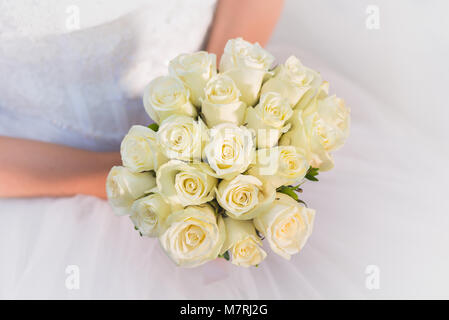 Bouquet of white roses being held by a bride Stock Photo - Alamy