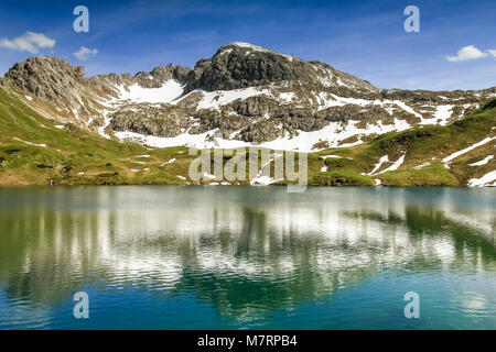 Remote Schrecksee lake up high in the alpine mountains in spring or ...