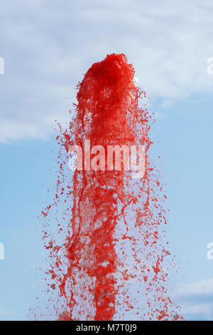 A liquid fountain spraying water against an electric blue sky, creating ...