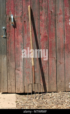 A Pitchfork leaning on a old red barn Stock Photo - Alamy