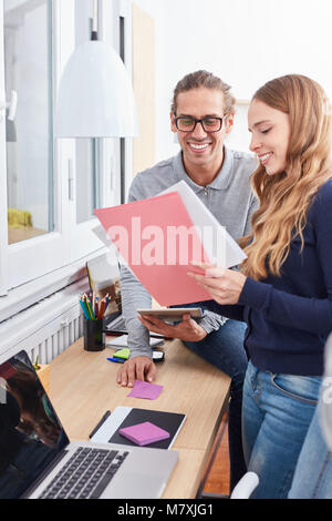 Two students work together on a homework project, using notebooks and ...
