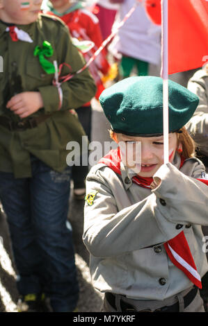 A small Polish scouting girl marches and holds the Polish flag during ...