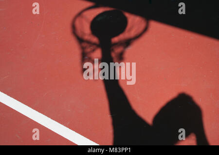 A Shadow Basketball player dunking on red court Stock Photo - Alamy