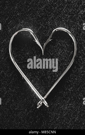 Fishing hook heart shape on yellow background Stock Photo - Alamy