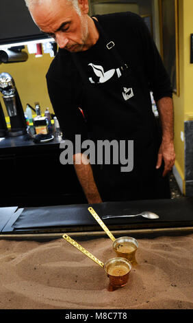 Greek coffee brewed in the hot sand in a traditional Greek coffee house ...