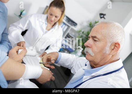 doctor is bandaging upper limb of patient Stock Photo - Alamy