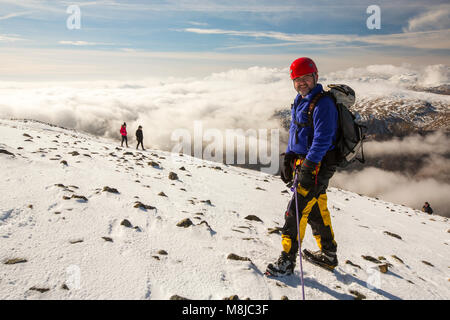 A climber just having summited a winter climb on Helvellyn, Lake ...