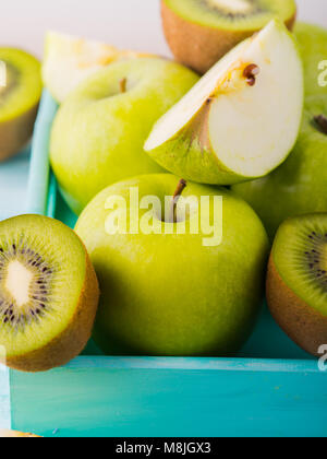 Green apples and kiwi on turquoise background Stock Photo - Alamy