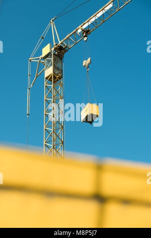 Construction crane against the background of buildings completing the ...