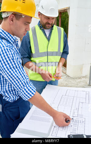 Builders Checking Floor Plans on Site Stock Photo - Alamy