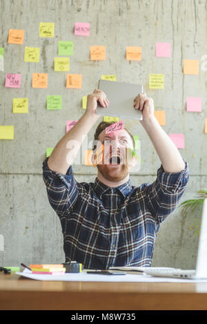 Stressed man with message on sticky notes over his face in office Stock ...