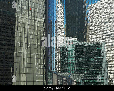 Abstract reflections of buildings in the curved green glass façade of ...