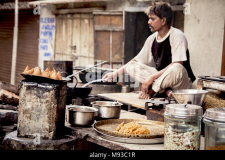 Indian man cooking deep fried Indian bread Wadai made from wheat flour ...