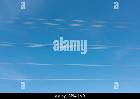 Power lines against blue sky Stock Photo - Alamy