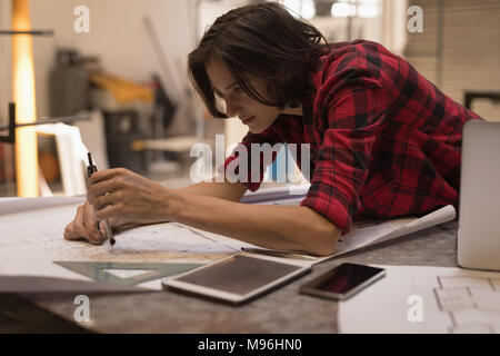 Female welder using compass in workshop Stock Photo - Alamy