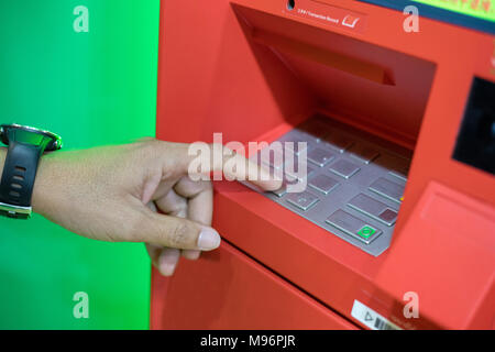 Close-up of hand entering PIN/pass code on ATM/bank machine keypad ...