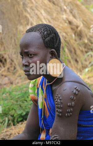 Mursi Tribe in The Omom River Valley, Ethiopia. A young tribeswoman ...