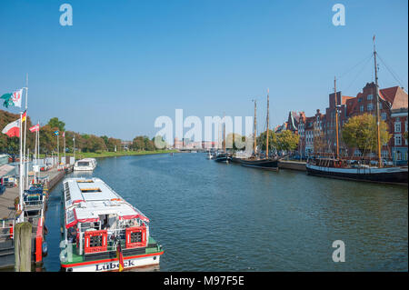 A boat sailing on the Trave river surrounded by traditional buildings ...
