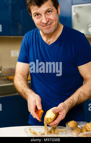 Man peeling potatoes on the counter in the kitchen Stock Photo - Alamy