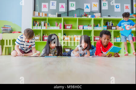 Group of kid lay down on floor together. four little girls have fun ...