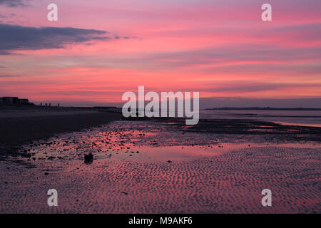 Pink sunset on Seasalter beach, Whitstable, Kent, UK, March 2018 with a ...