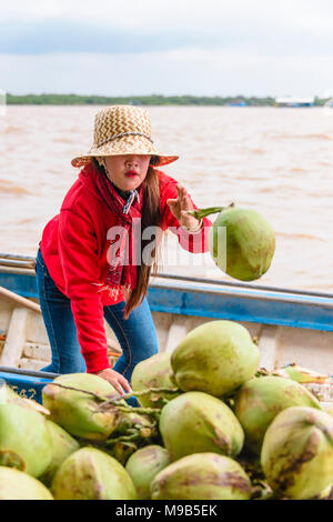 Women offload their cargo of coconuts from their wooden motorboat on ...
