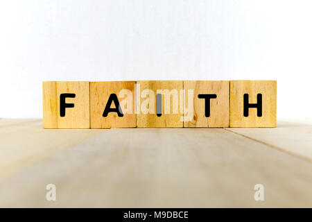 Faith, words on wooden cube blocks on dark brown wood background, close ...