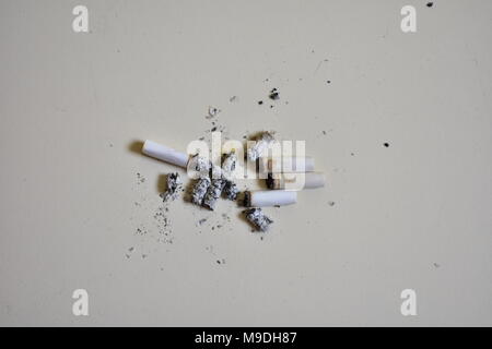 A lot of cigarette piece with ash after smoking shattered on the floor ...