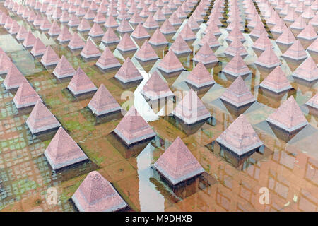 Small burnt red concrete pyramids reflected in the water in the Memory ...