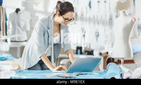 Beautiful Female Designer Uses Laptop on Her Desk that is Covered with ...