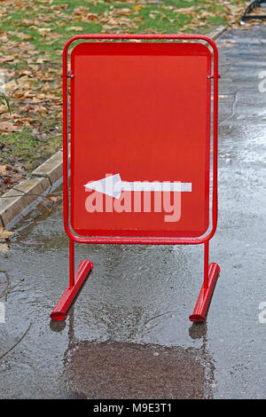 Red direction board at sidewalk Stock Photo - Alamy