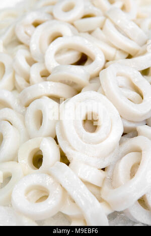 Sliced raw rings squid in a rustic plate with rosemary. Dark background ...