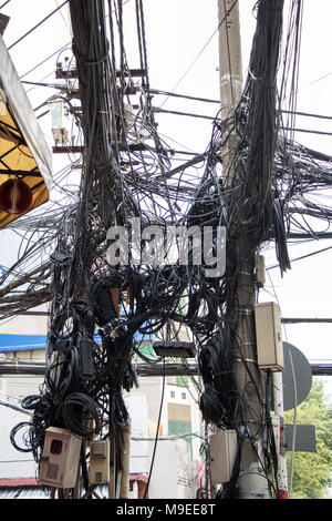 Messy wires attached to the electric mast. The chaos of cables and ...