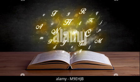 Glowing yellow alphabet letters coming out of an open book Stock Photo ...