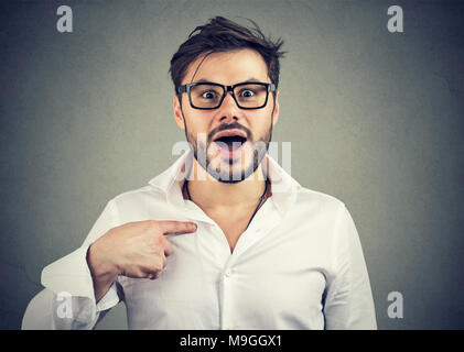 Happy and surprised man pointing at himself, smiling pleased, standing ...