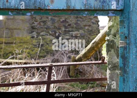Abandoned ruined building with a red tin roof and three chimneys in the ...