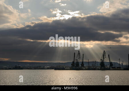 Sunray over Varna port, silhouette of cranes Stock Photo - Alamy