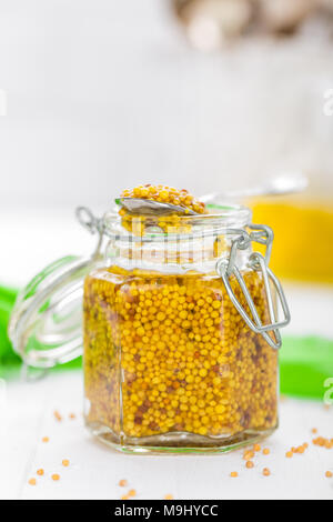Mustard in glass jar on white wooden table closeup. Dijon mustard Stock ...