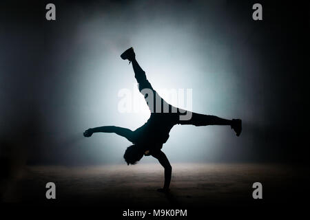 B-Boy performing one handed freeze. Guy breakdancer stands on arm and ...