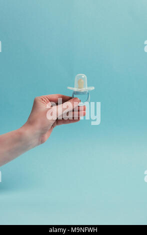 Hand holding pacifier isolated Stock Photo - Alamy