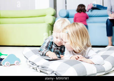 Cute kids review the book Stock Photo - Alamy