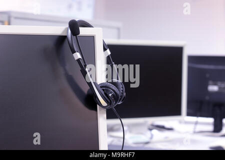 Microphone hanging over desk with headphones, soundboard and laptop ...
