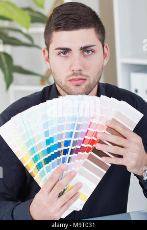 Man with color palettes on green background Stock Photo - Alamy