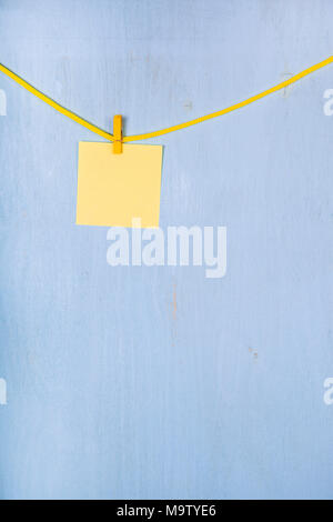 Blank blue paper card hang with clothespin on rope. Copy space. Place ...