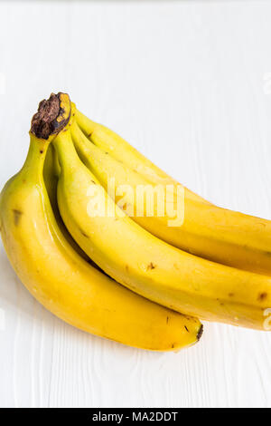 Close up bunch of ripe banans lying on white wooden surface Stock Photo ...
