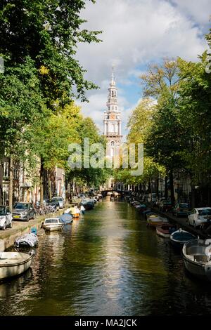 View of Zuiderkerk along Groenburgwal canal at night with reflections ...