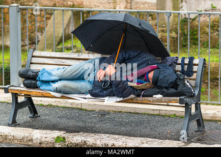 Homeless beggar with umbrella in the rain Stock Photo - Alamy
